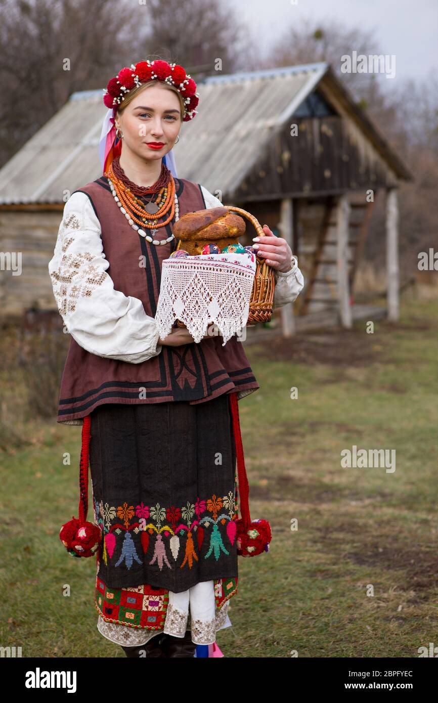 Beautiful girl in national dress with Easter and eggs in a basket ...