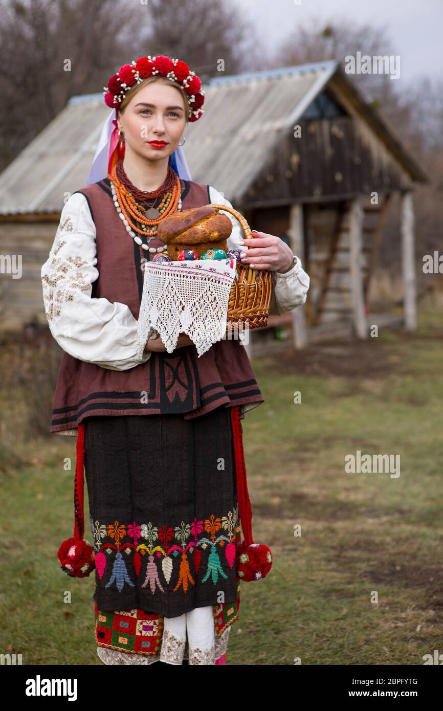 Beautiful girl in national dress with Easter and eggs in a basket ...