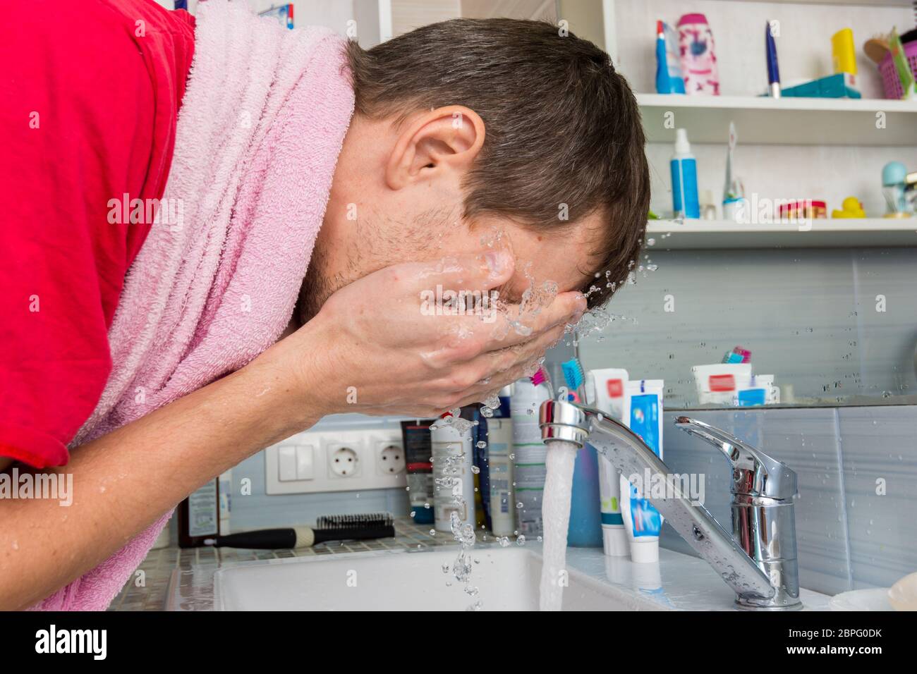 Man washing his face in the morning in the bathroom Stock Photo - Alamy