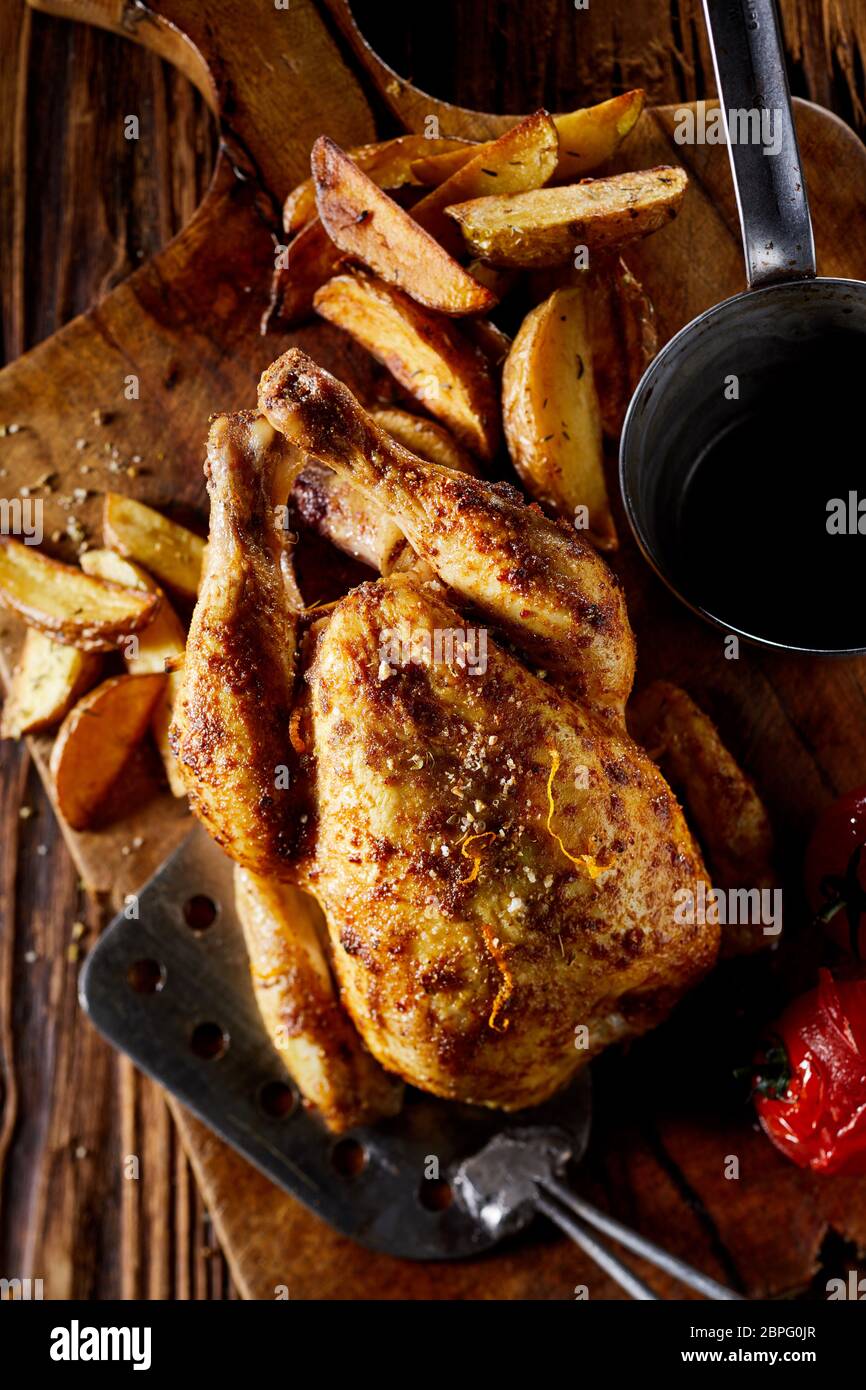 Grilled seasoned poisson or spring chicken served with fried potato ...