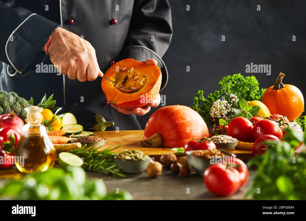 Vegetarian chef removing pips from a squash or pumpkin surrounded by ...