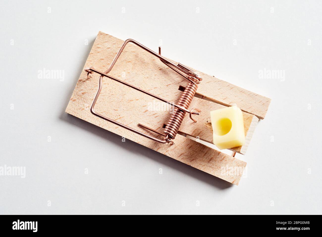 Loaded spring wooden mousetrap with piece of cheese, viewed in close-up ...
