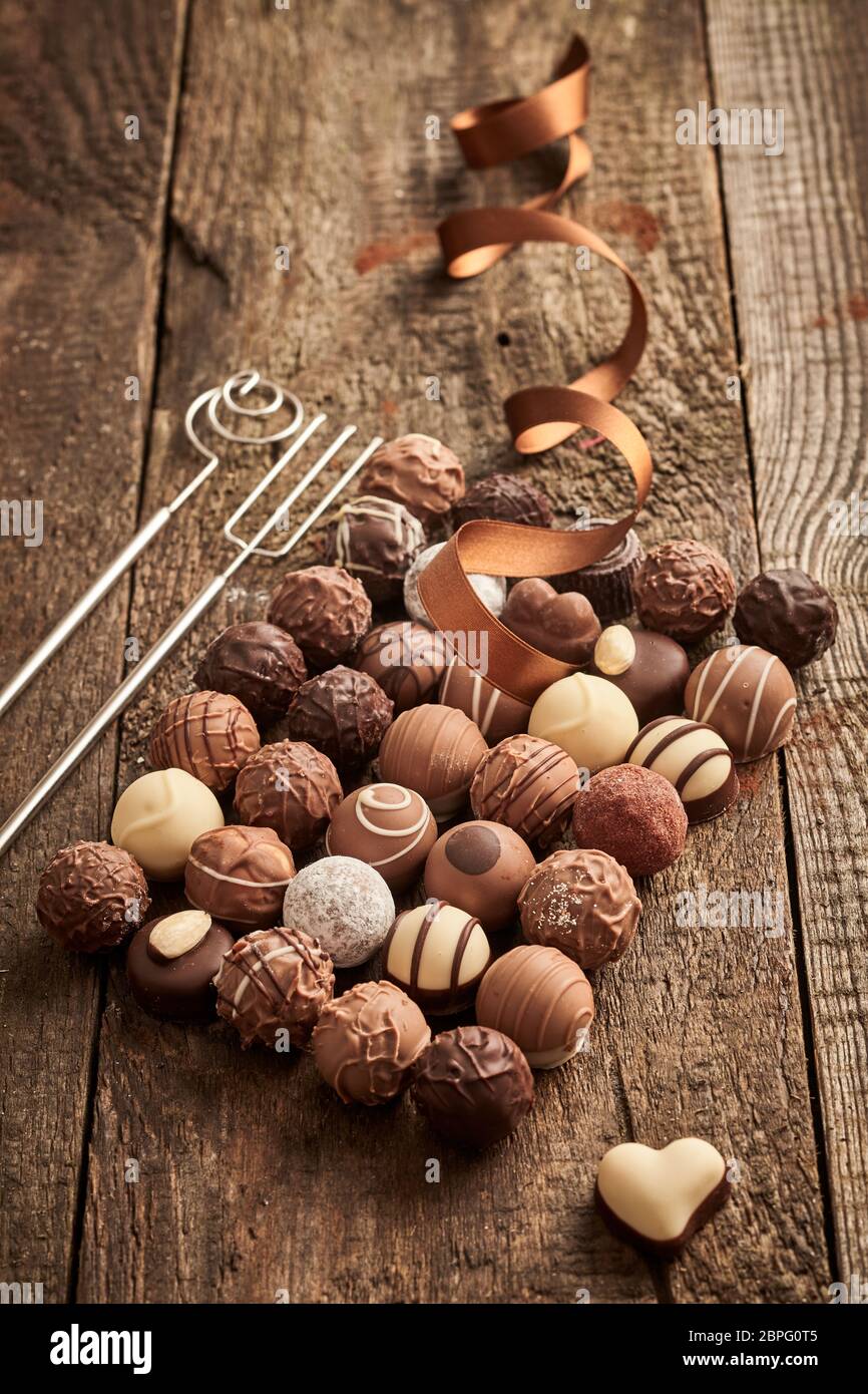 Large assortment of luxury handmade chocolate pralines on rustic wood ...