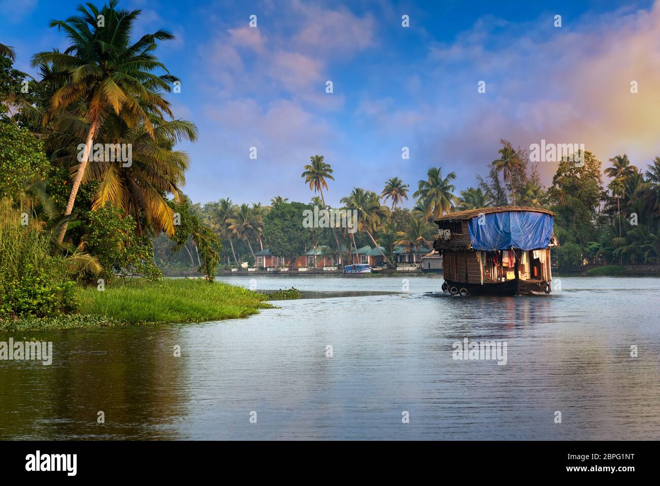 A traditional house boat is anchored on the shores of a fishing lake in ...