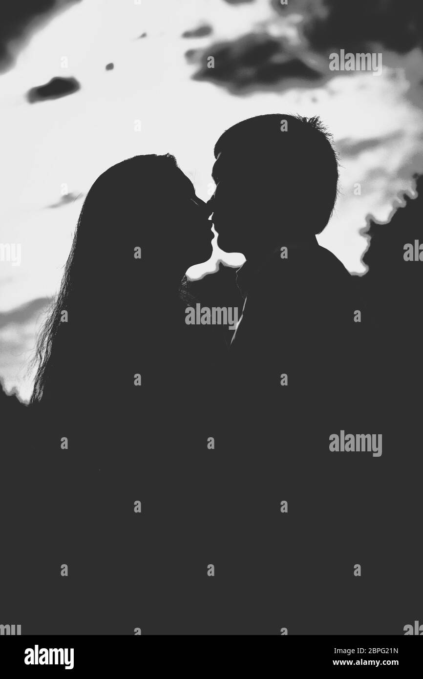 Beautiful young couple on the sunset background Stock Photo - Alamy