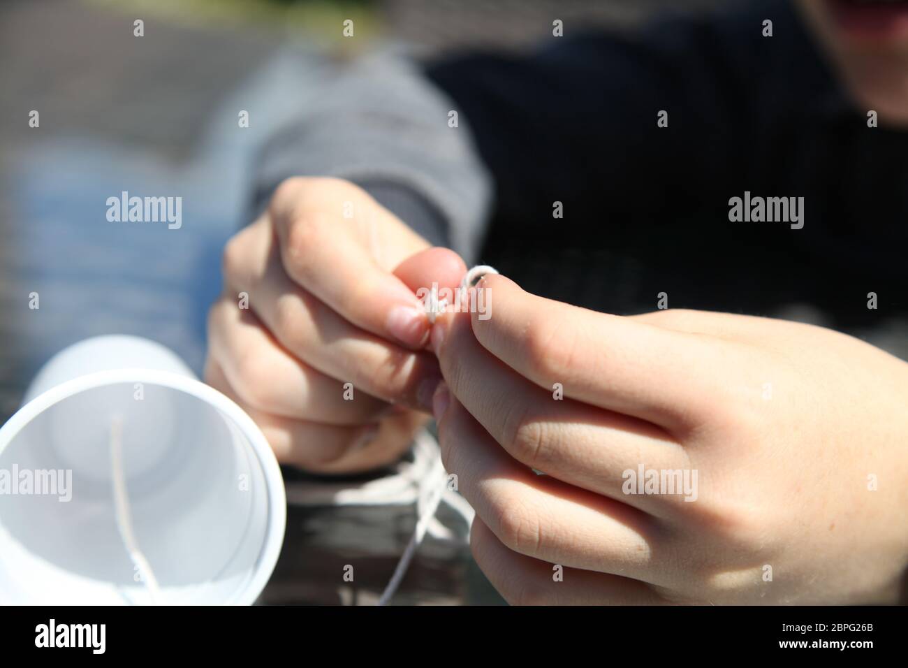 Making a telephone from plastic cups and string, boy doing science ...