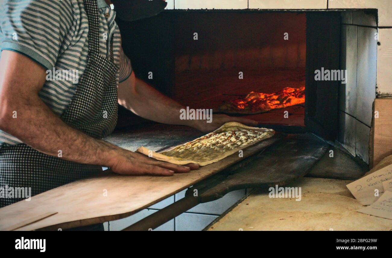 Turkish Muslim baker chef putting traditional ramadan bread of turkish ...