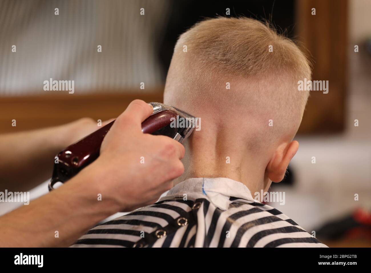 Men's hairstyling, haircutting, in a barber shop or hair salon. Close ...