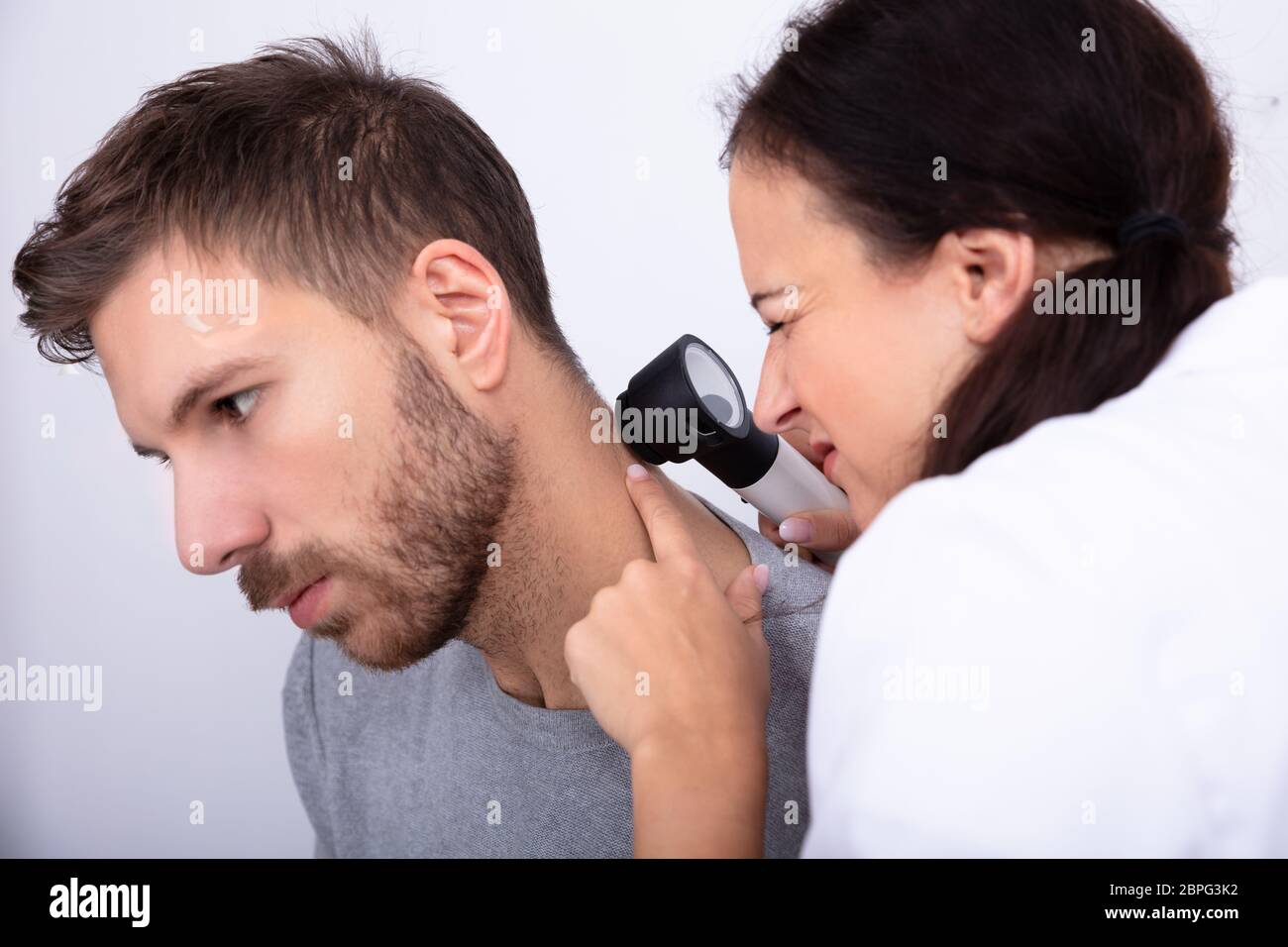 Close-up Of A Young Female Doctor Checking Skin On Man's Neck With ...