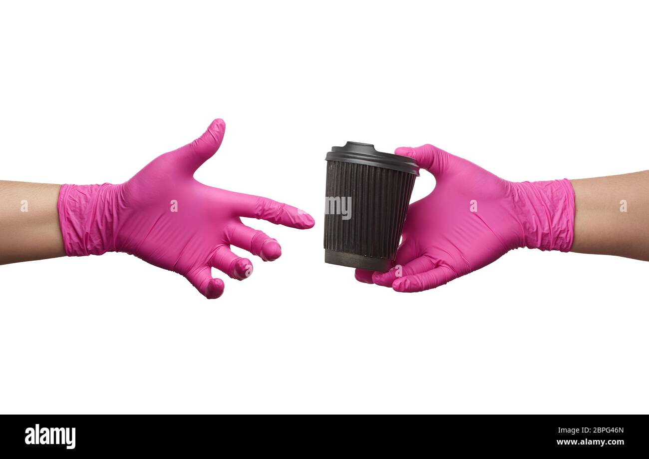 hand in a pink latex glove holds a paper disposable cardboard cup and ...