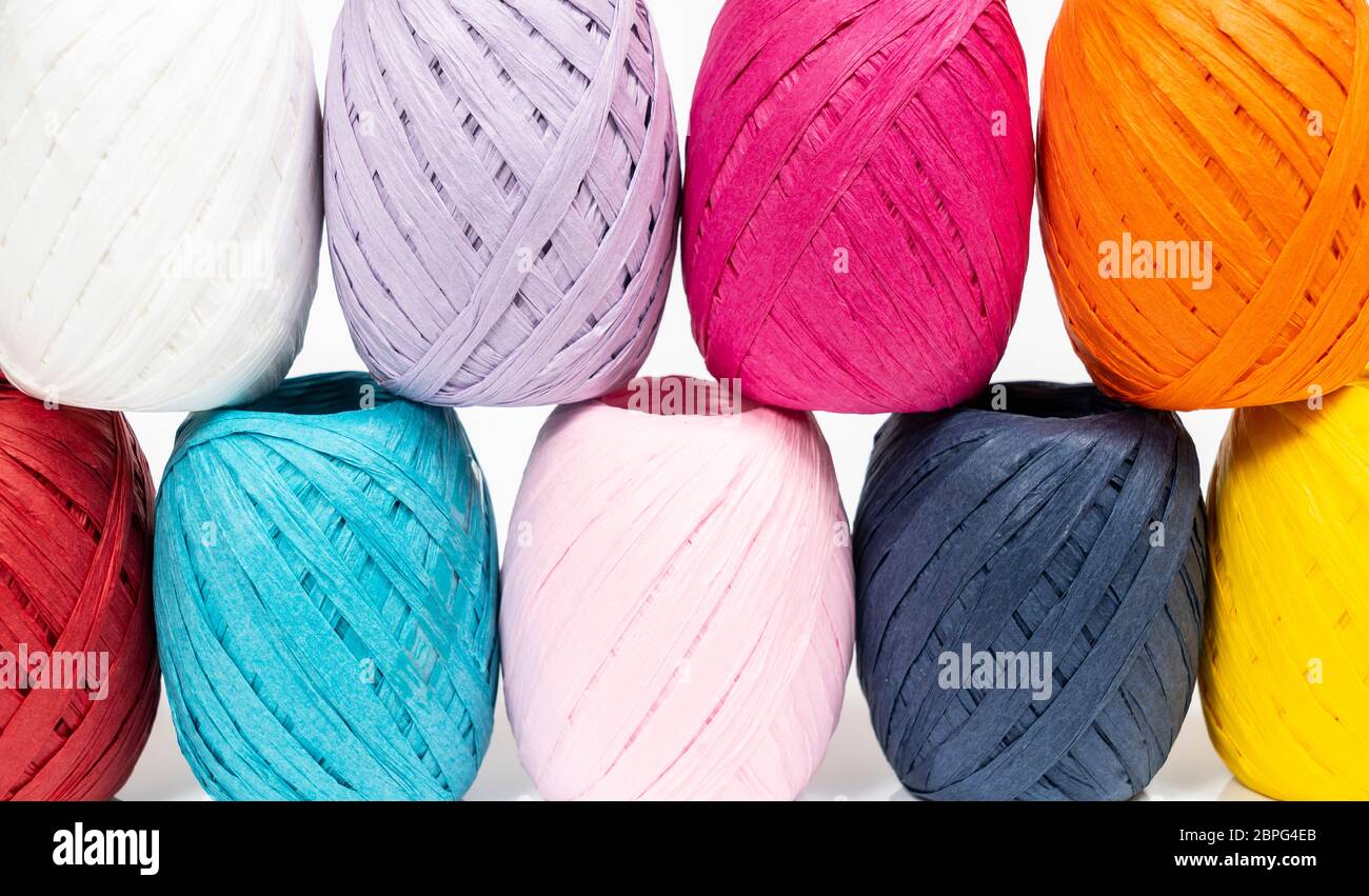 some balls of colored raffia on a white surface Stock Photo - Alamy