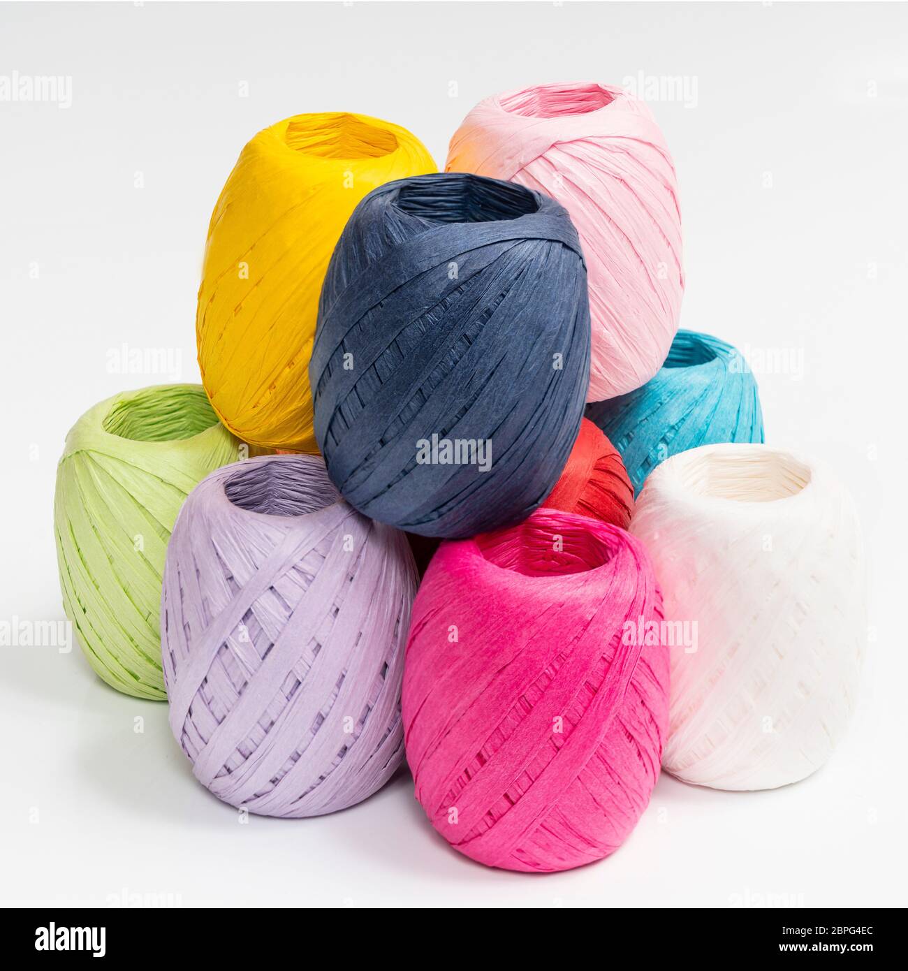 some balls of colored raffia on a white surface Stock Photo - Alamy