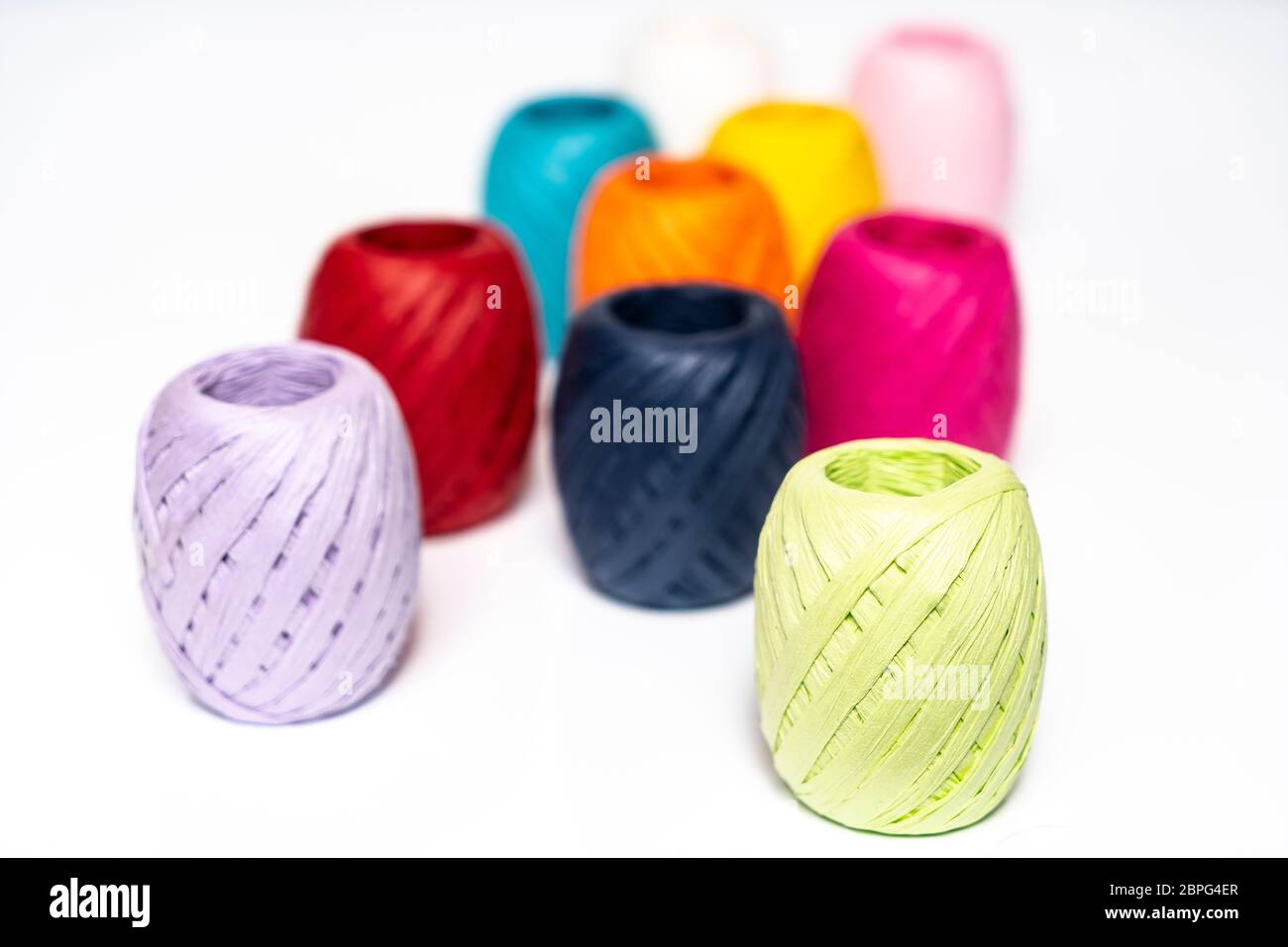 some balls of colored raffia on a white surface Stock Photo - Alamy