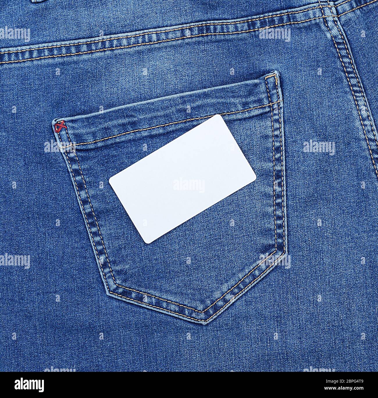 white empty business card on the back pocket of blue jeans, close up ...