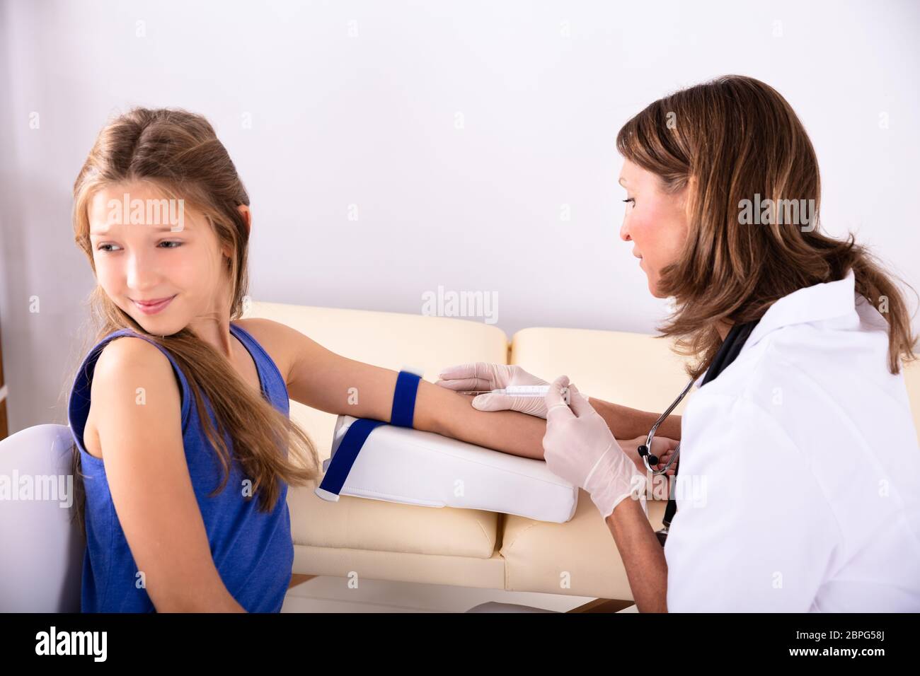 Side View Of Female Doctor Taking Blood Sample Of An Afraid Child ...