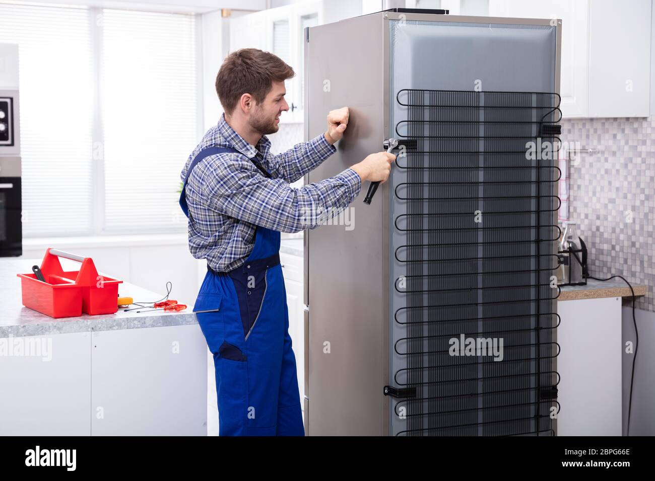 Electrician working on fridge in home hi-res stock photography and ...