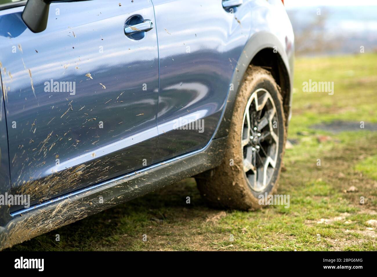 Close up of dirty car wheel with rubber tire covered with yellow mud ...