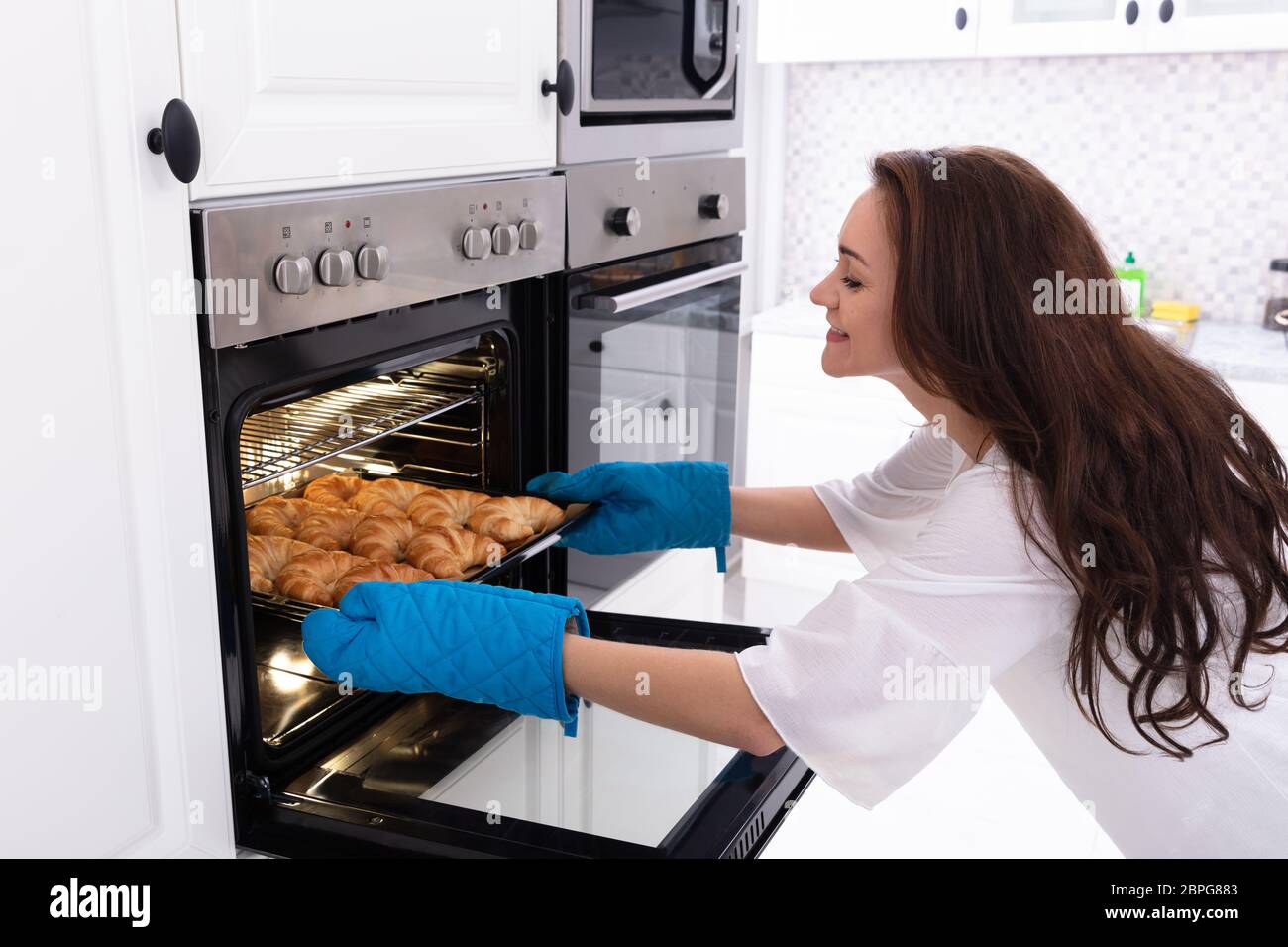 Woman kitchen using oven gloves hi-res stock photography and images - Alamy