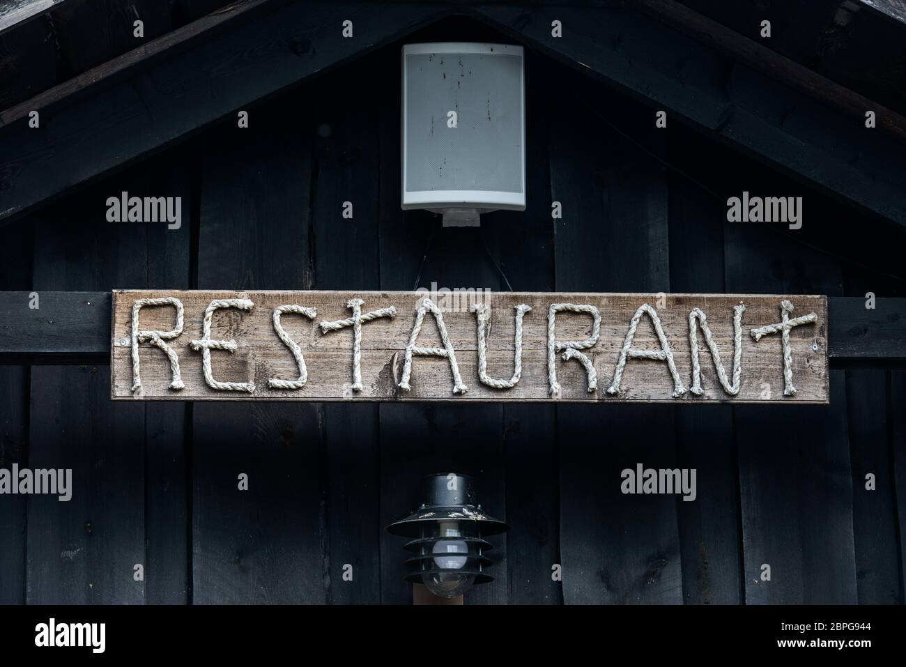 Wooden restaurant sign against old building wall Stock Photo - Alamy