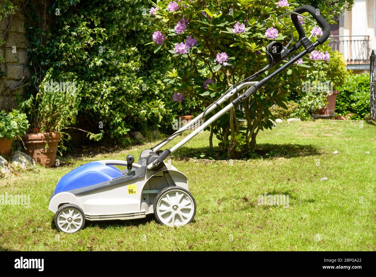 Blue Lawnmower in a garden during the work Stock Photo - Alamy