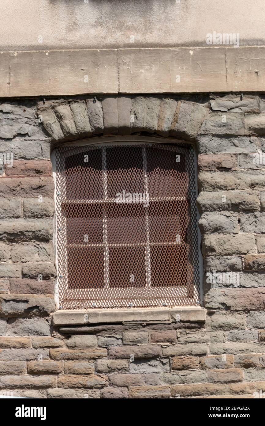 a close up view of a lower level window that has security mess covering ...