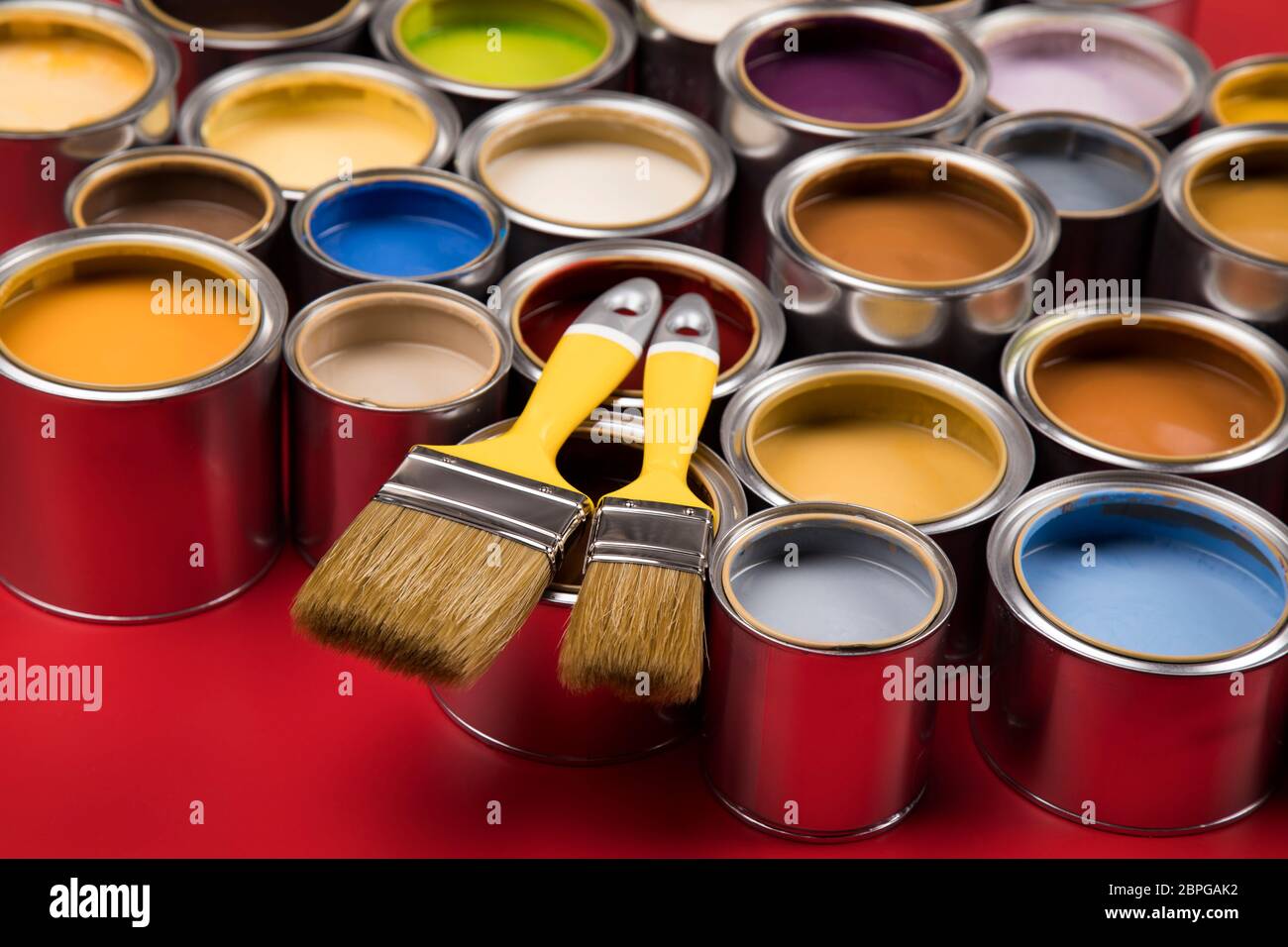 Open buckets with a paint and brush, red background Stock Photo - Alamy