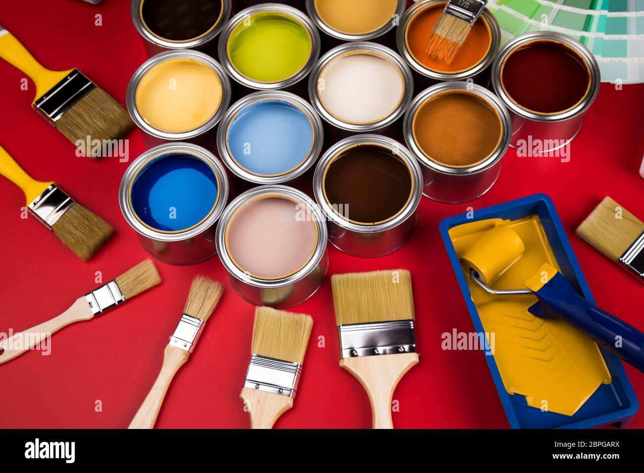 Open buckets with a paint and brush, red background Stock Photo - Alamy