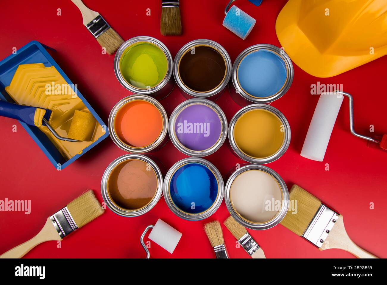 Open buckets with a paint and brush, red background Stock Photo - Alamy