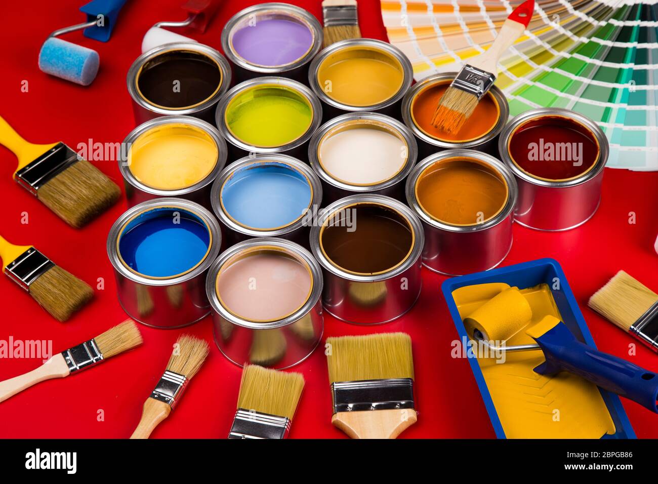Collection of colored paints cans, Brush, red background Stock Photo ...