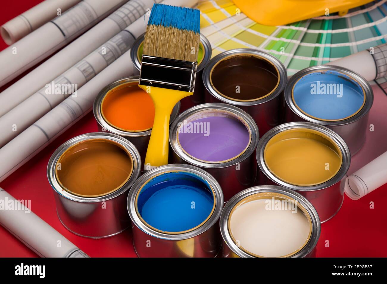 Open buckets with a paint and brush, red background Stock Photo - Alamy