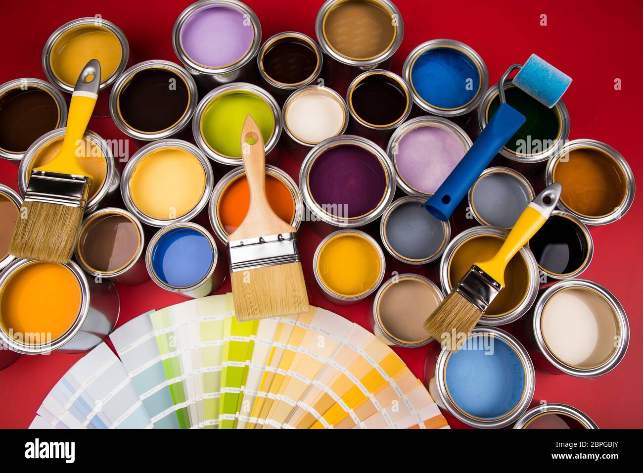Open buckets with a paint and brush, red background Stock Photo - Alamy