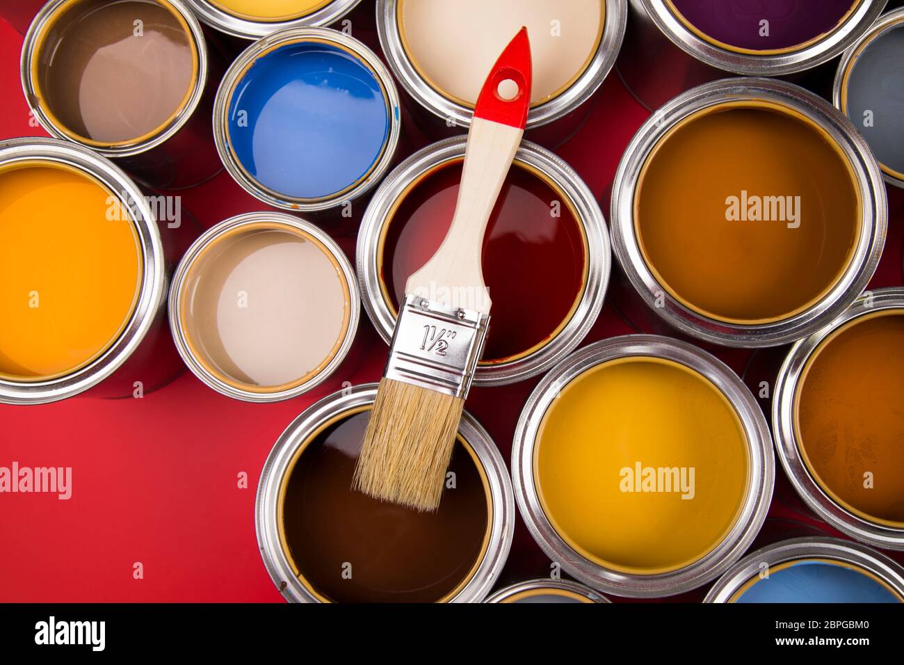 Open buckets with a paint and brush, red background Stock Photo - Alamy