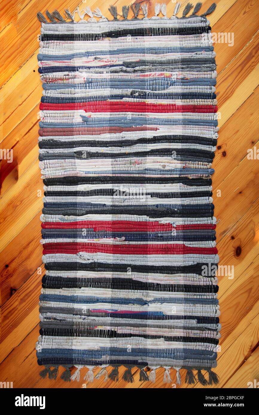 Rustic wicker rug on a wooden floor. Multi-colored Slavic carpet Stock ...