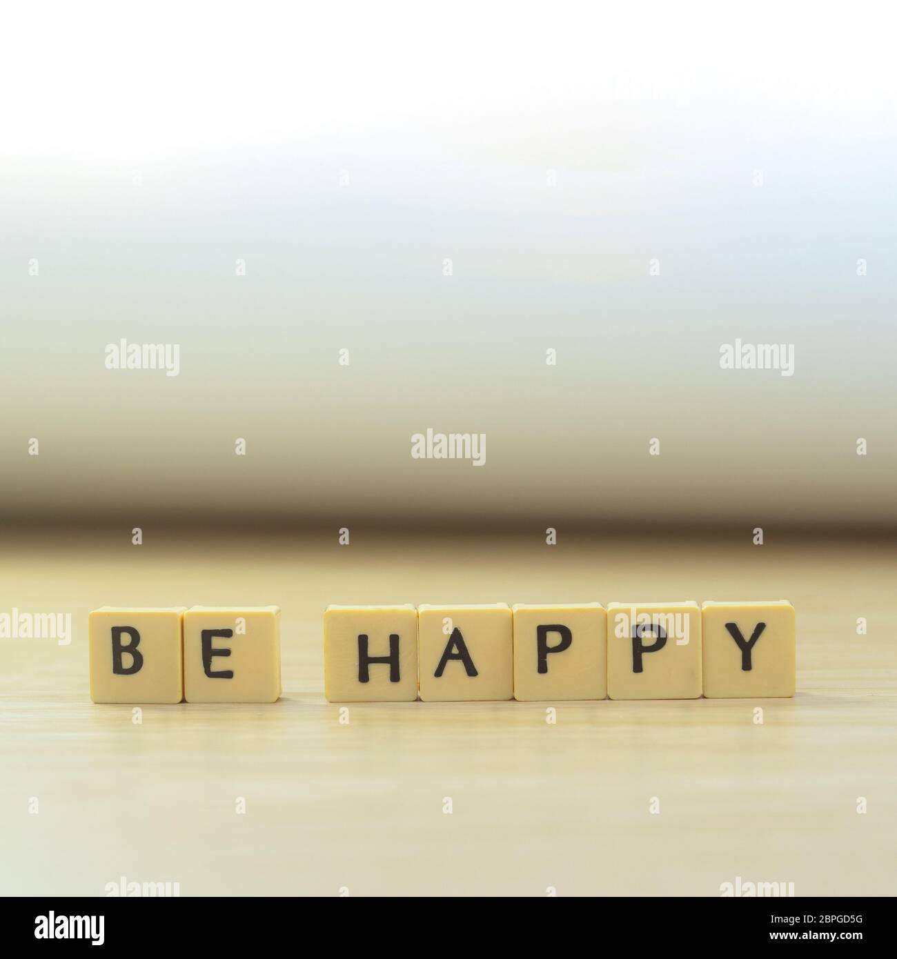 be happy word written in cube on wooden floor on white background ...