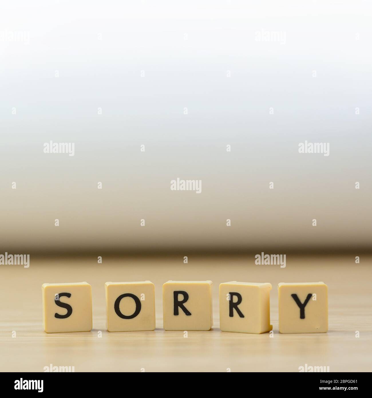 sorry word written in cube on wooden floor on white background, letter ...