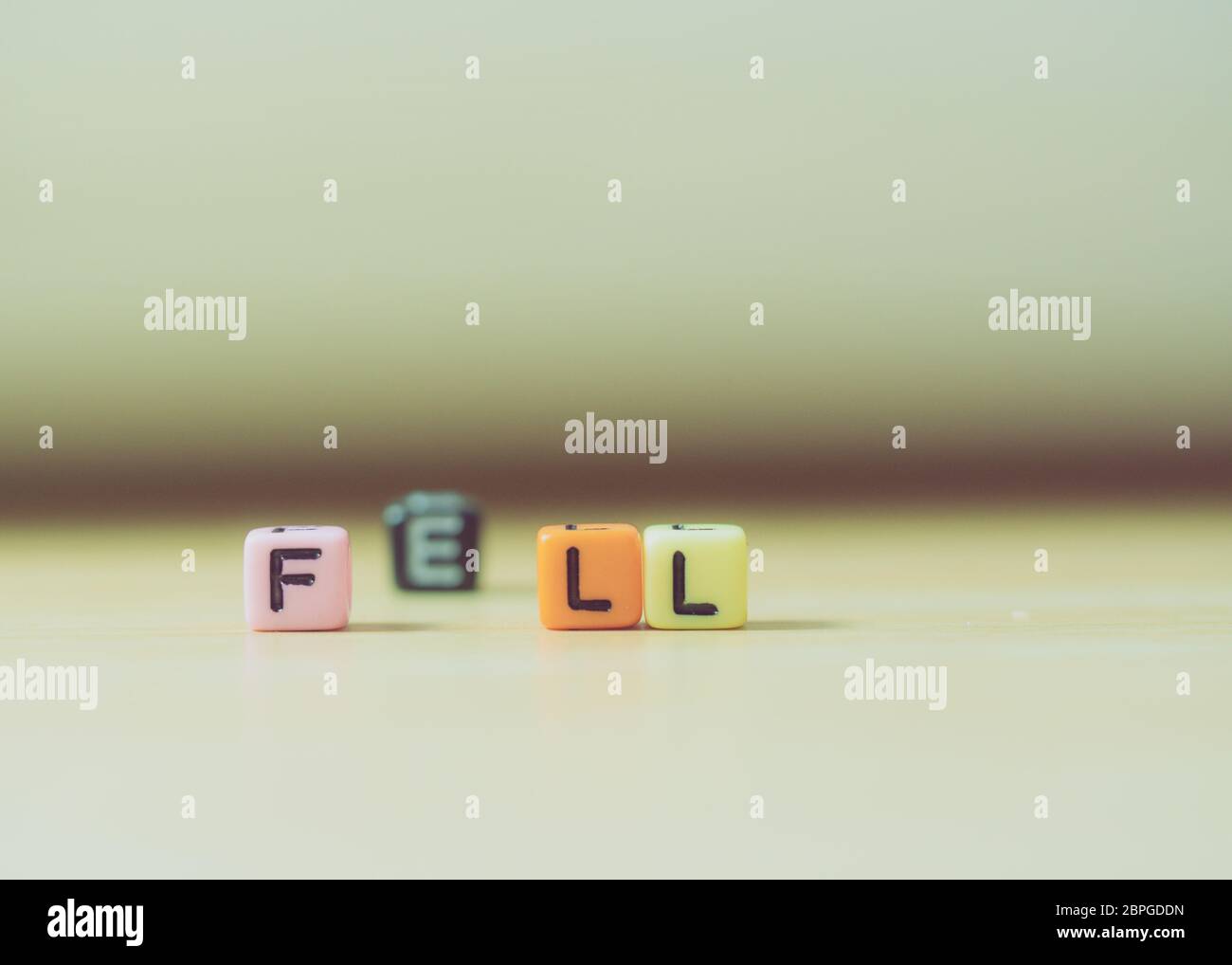 FELL word written in cube on wooden floor on white background, letter ...