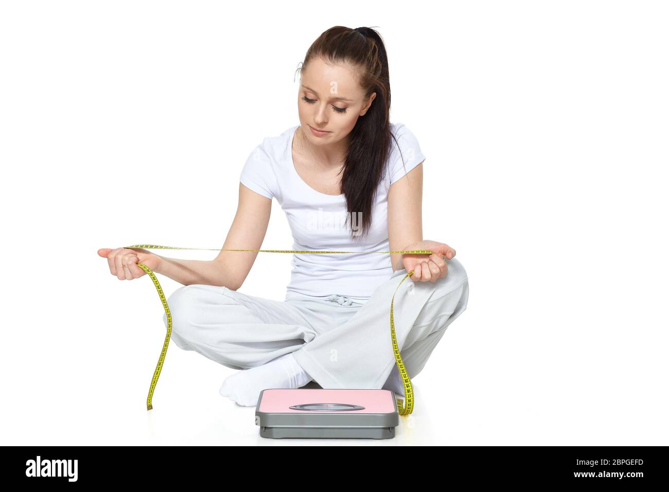 Young beautiful woman with scales on a white background Stock Photo - Alamy