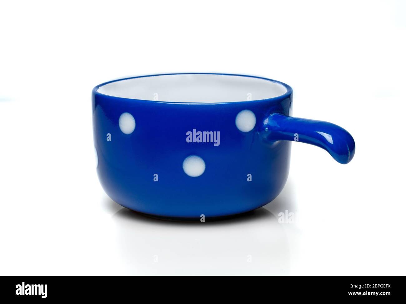 Blue cup with white polka dots on a white background Stock Photo - Alamy