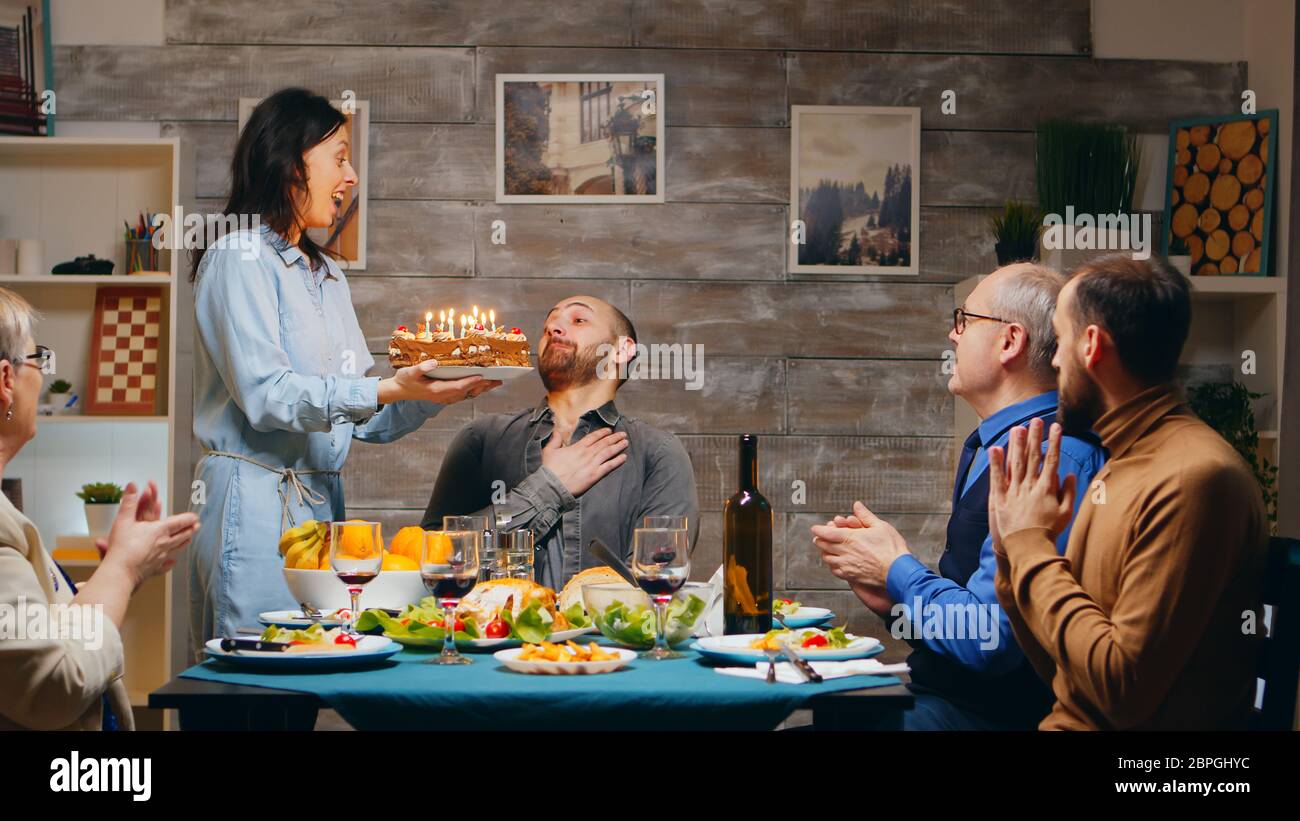Young man celebrating his birthday with the family. Dinner food ...