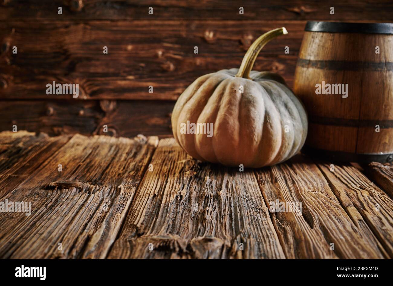 Big pumpkin and oak barrel in wooden house room on table with old harsh ...