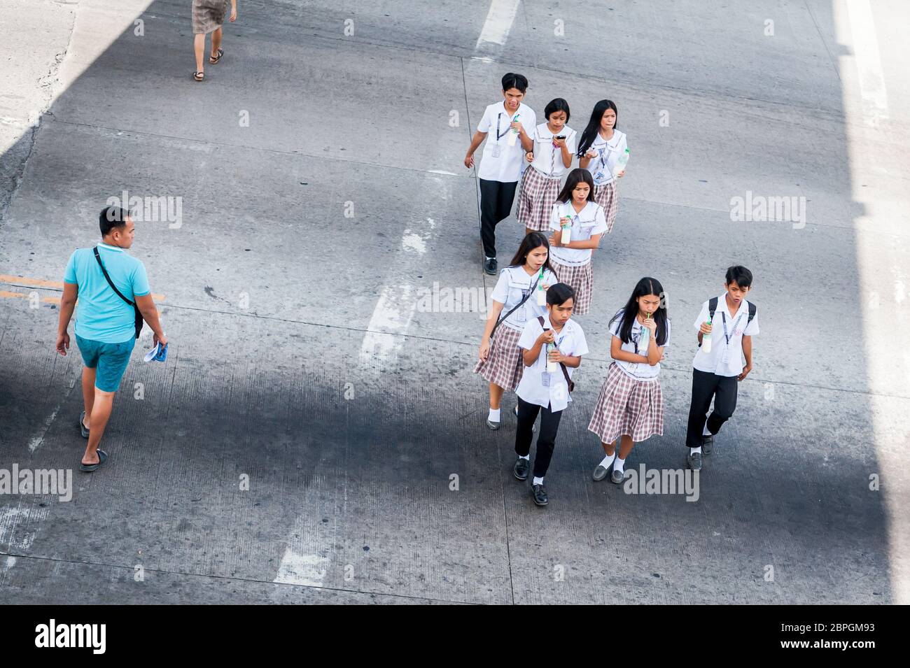 A group of Filipino school children cross a busy junction in Angeles ...
