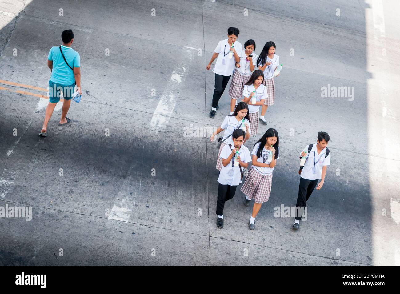 A group of Filipino school children cross a busy junction in Angeles ...