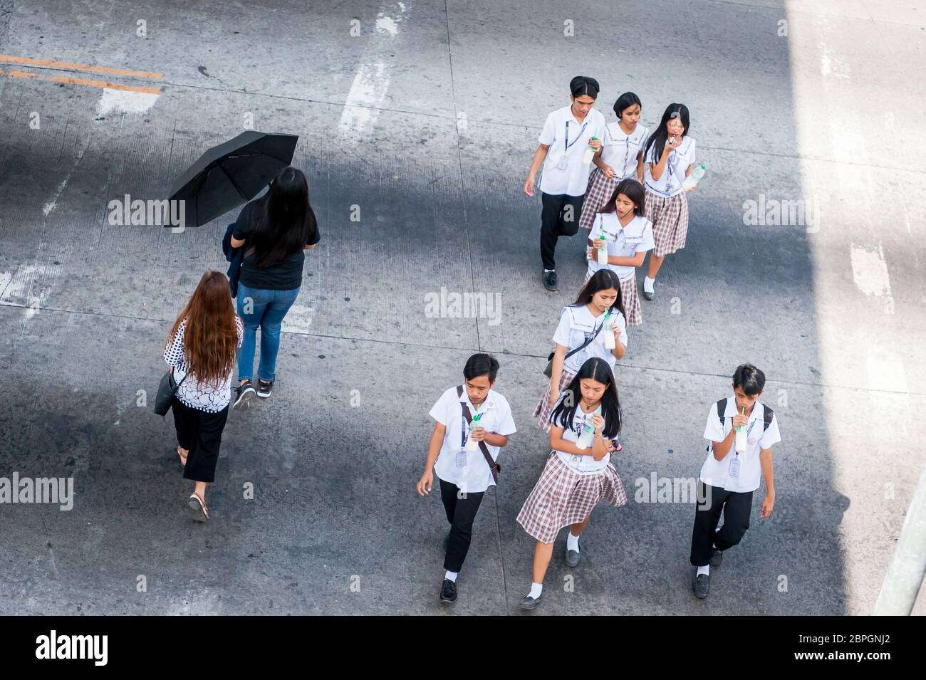 A group of Filipino school children cross a busy junction in Angeles ...