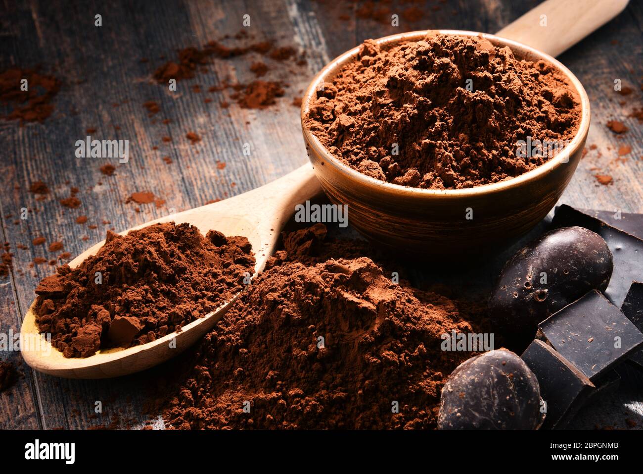 Composition with bowl of cocoa powder on wooden table Stock Photo - Alamy