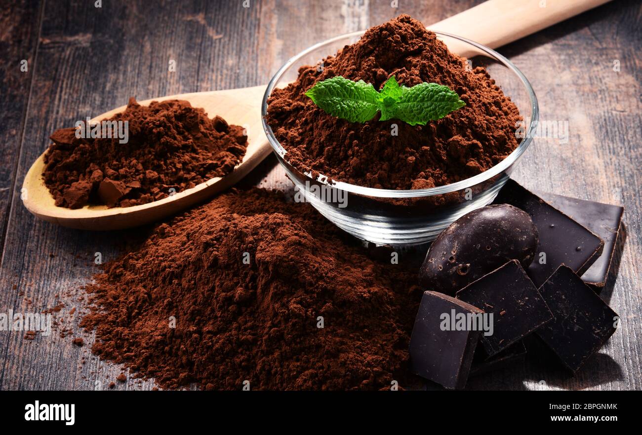 Composition with bowl of cocoa powder on wooden table Stock Photo - Alamy
