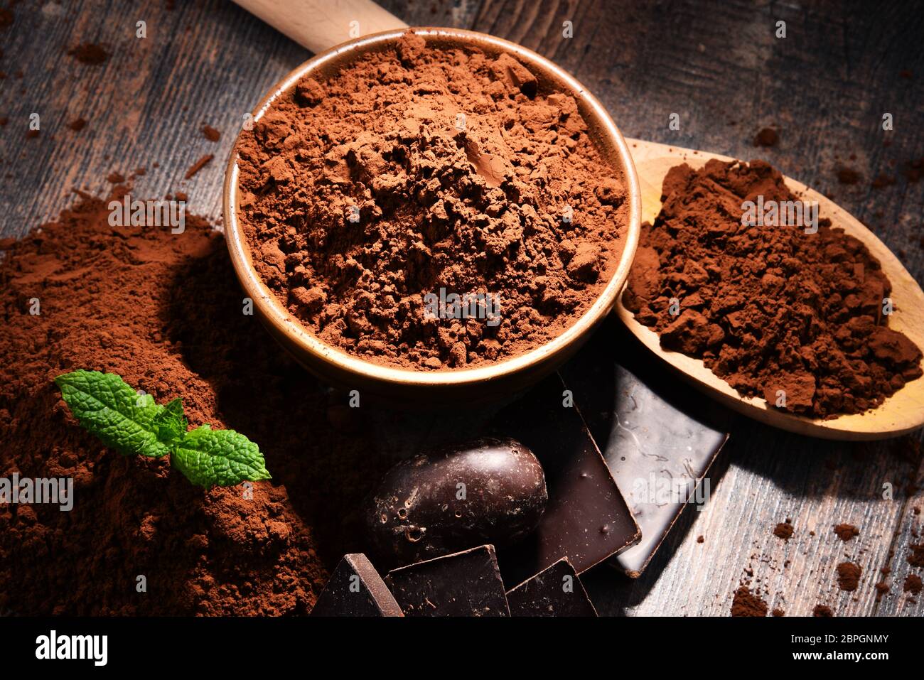 Composition with bowl of cocoa powder on wooden table Stock Photo - Alamy