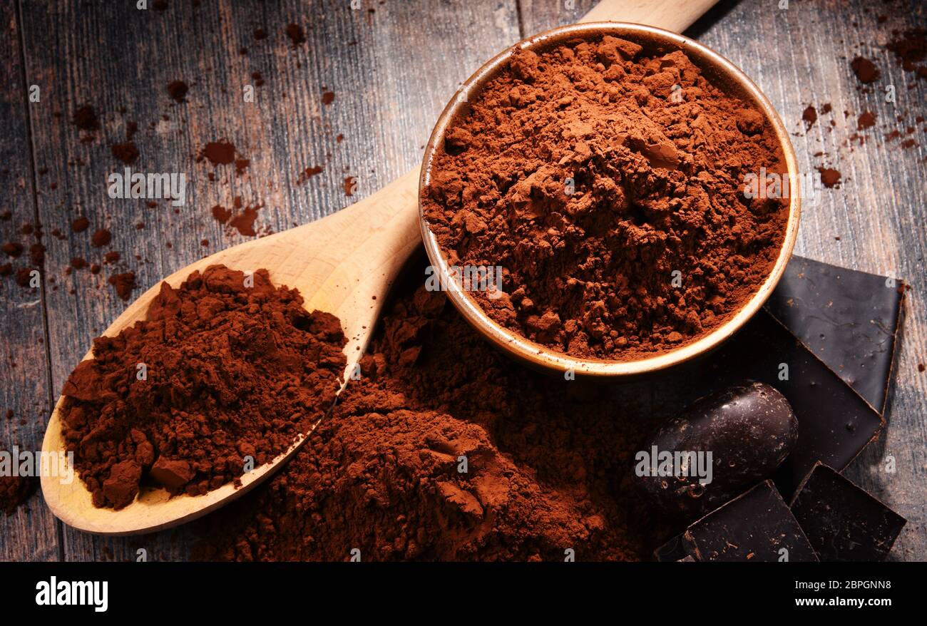 Composition with bowl of cocoa powder on wooden table Stock Photo - Alamy
