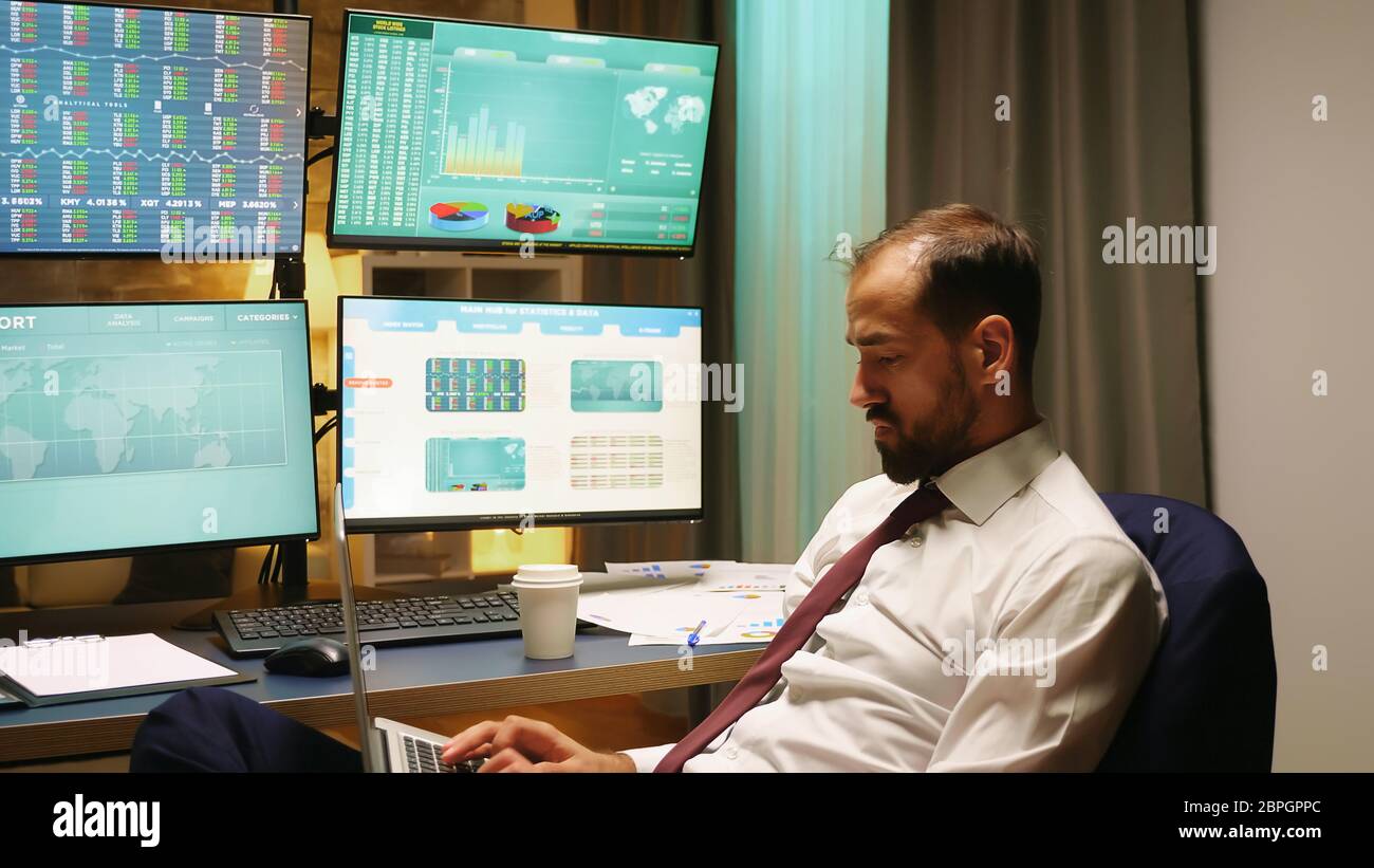 Stock market trader with suit and tie typing on laptop. Economy crash ...