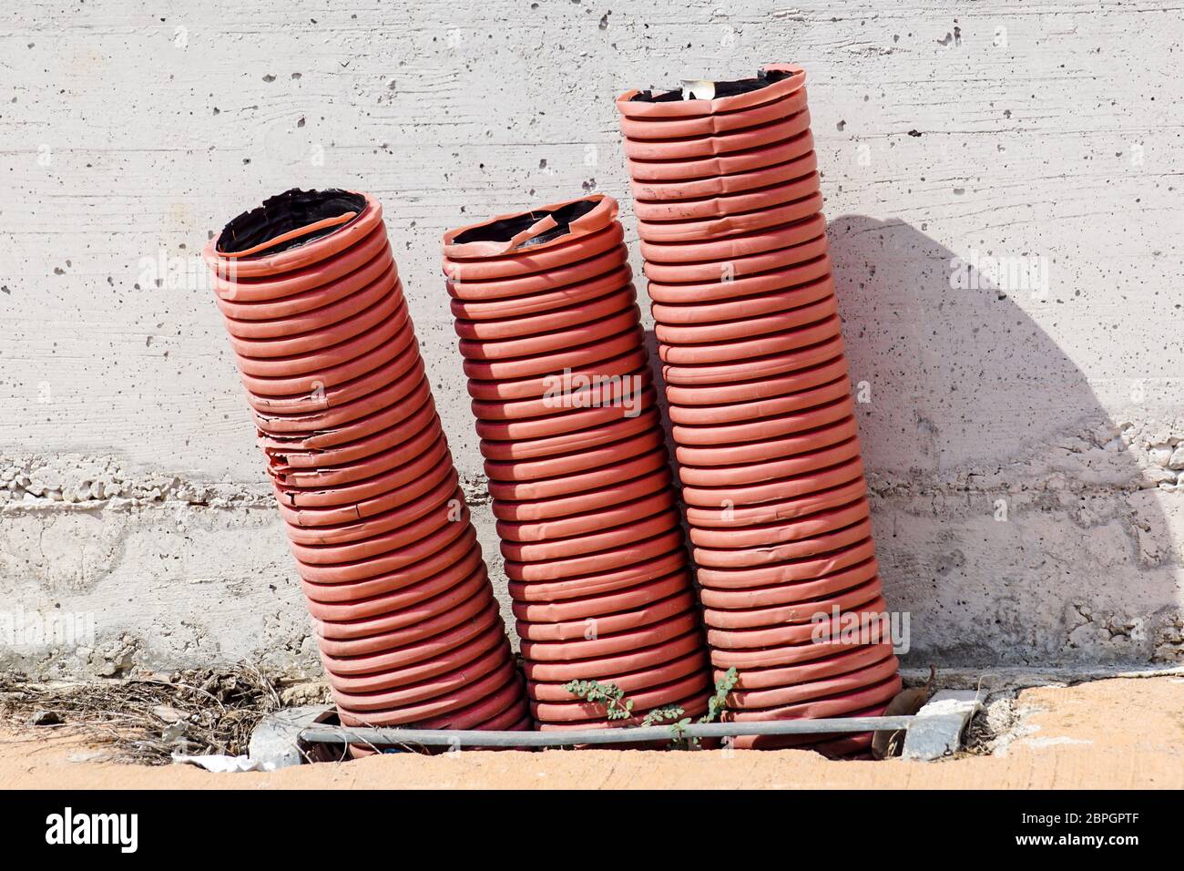 Red orange corrugated sheath for electric cables, on a building ...