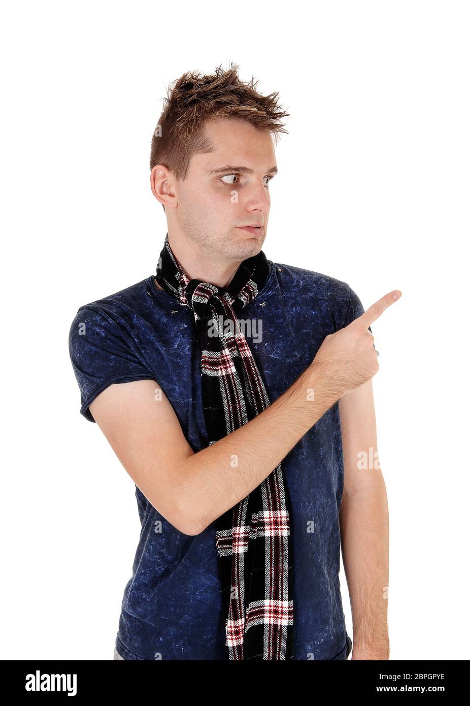 A young very angry man standing and pointing his finger to the side ...